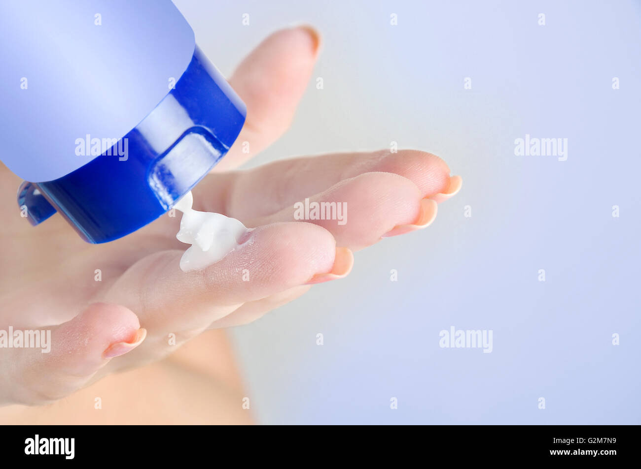 Hand with cream on blue background Stock Photo - Alamy