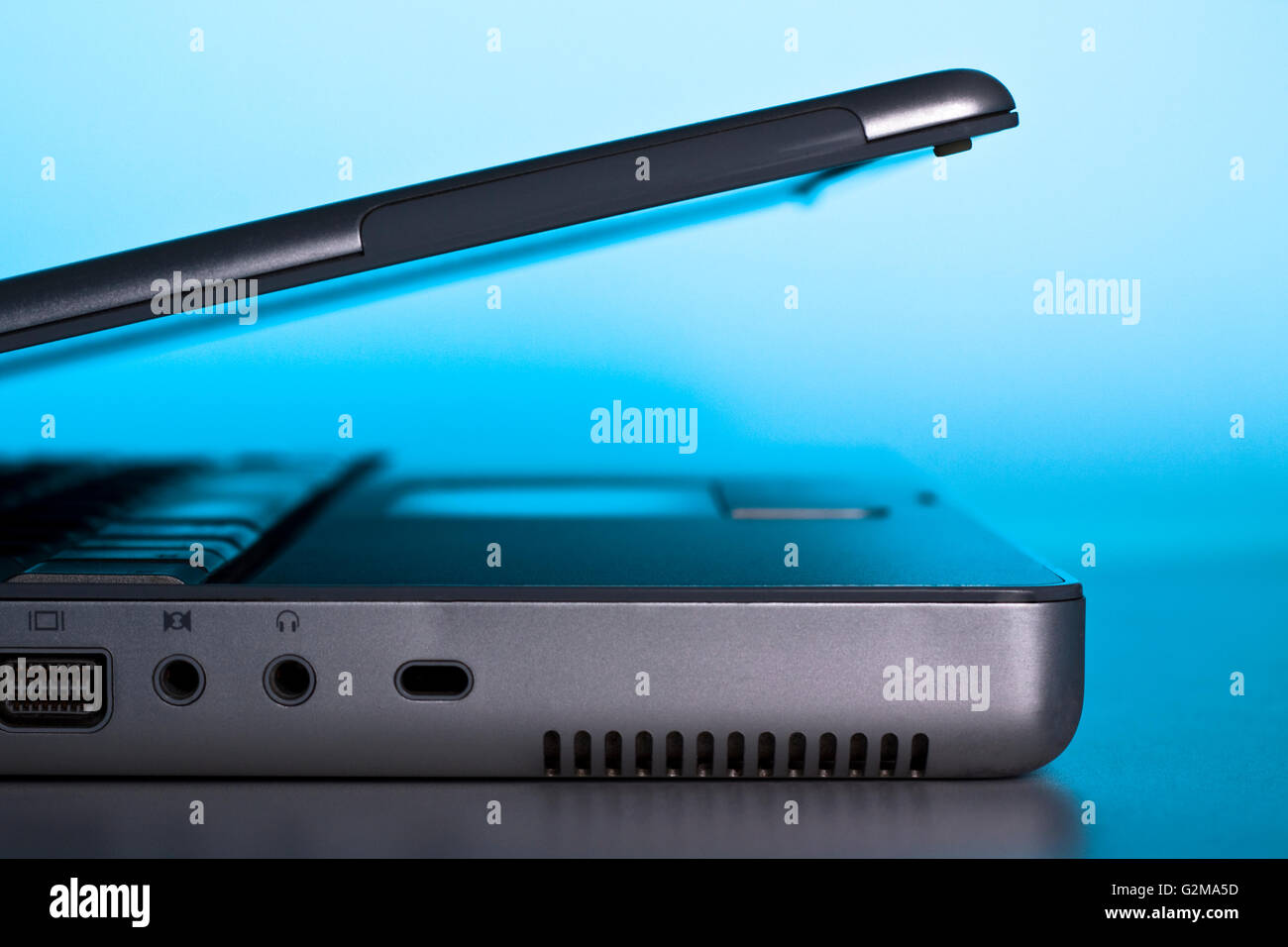 silver laptop side view lid open with blue background light Stock Photo ...