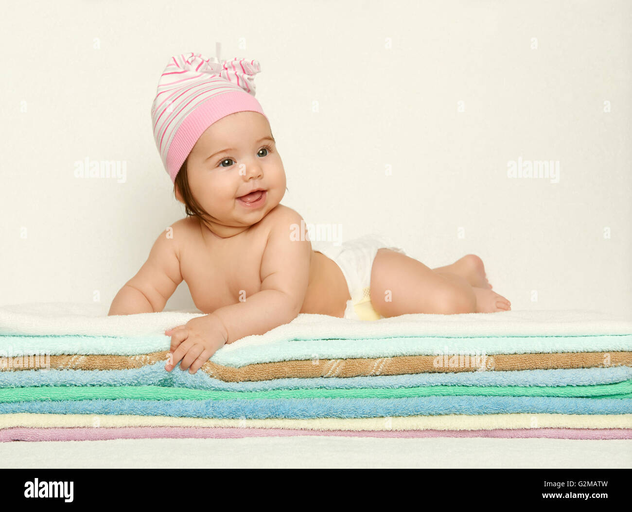 baby portrait in diaper on towel at studio, yellow toned background ...