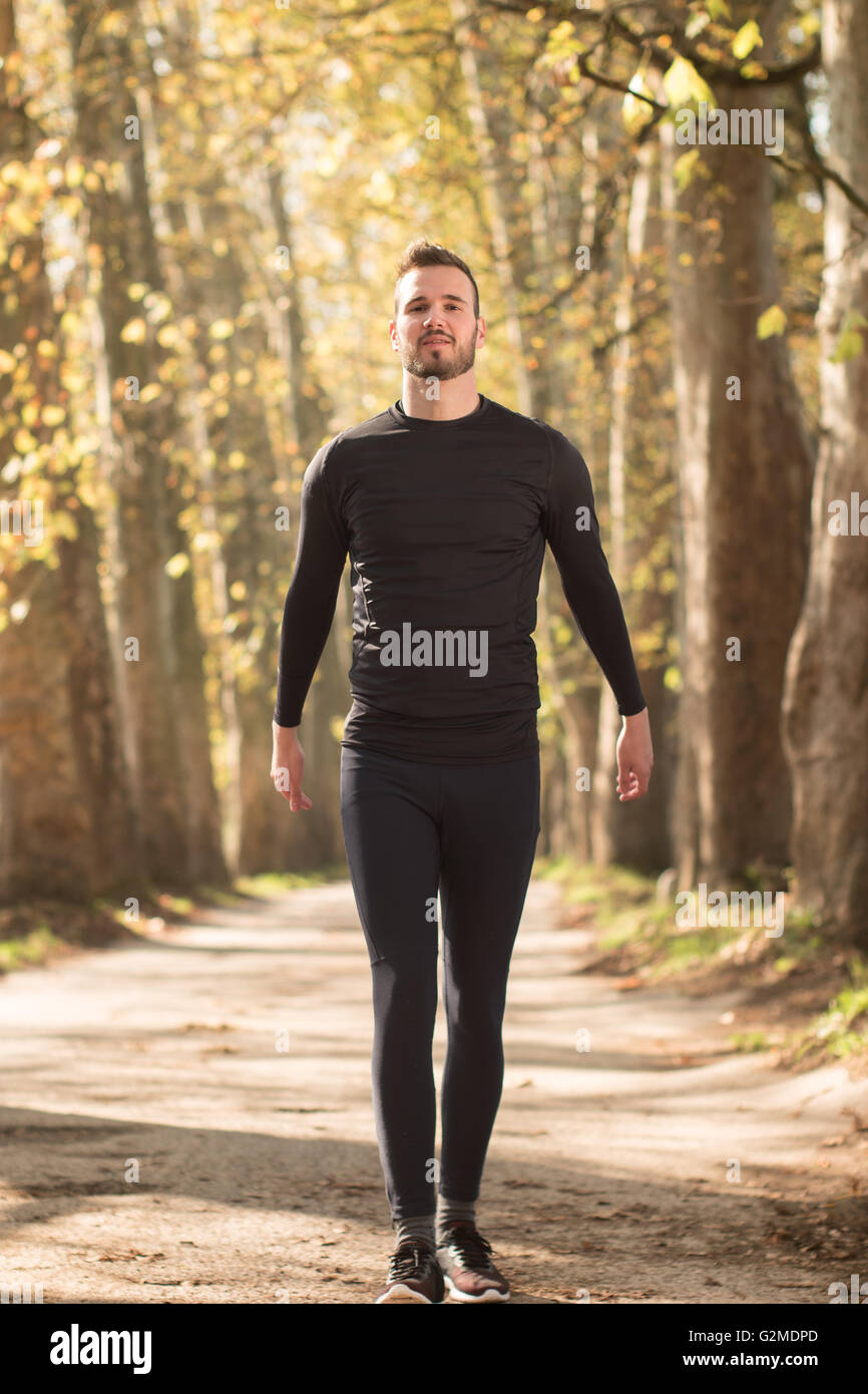 Runner resting tired and exhausted after running. Jogging man taking a ...