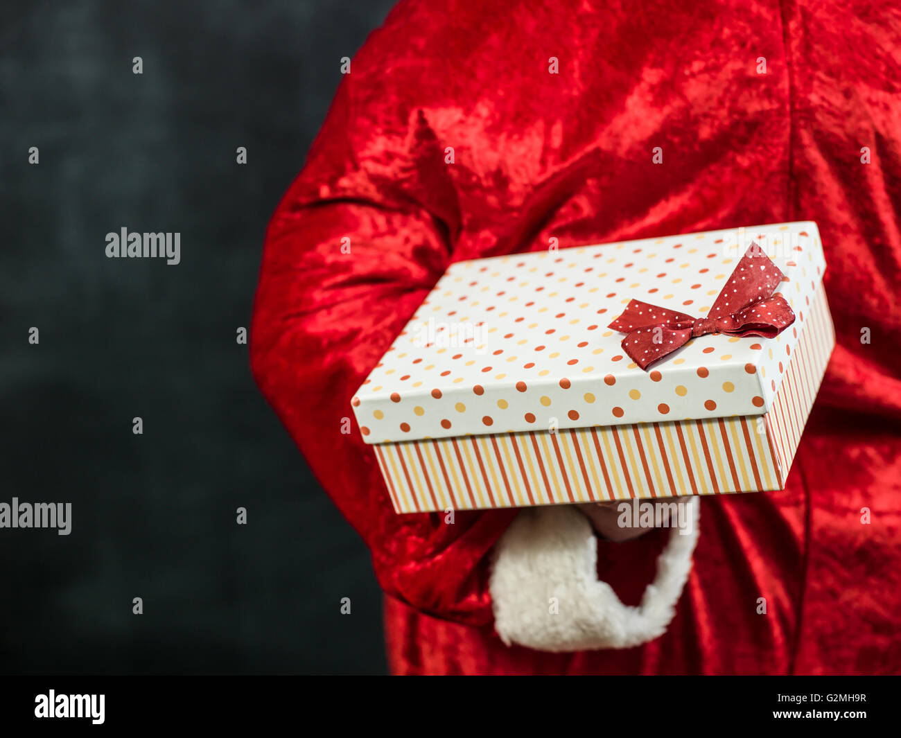 Santa sneaking in with a gift hidden behind his back Stock Photo - Alamy