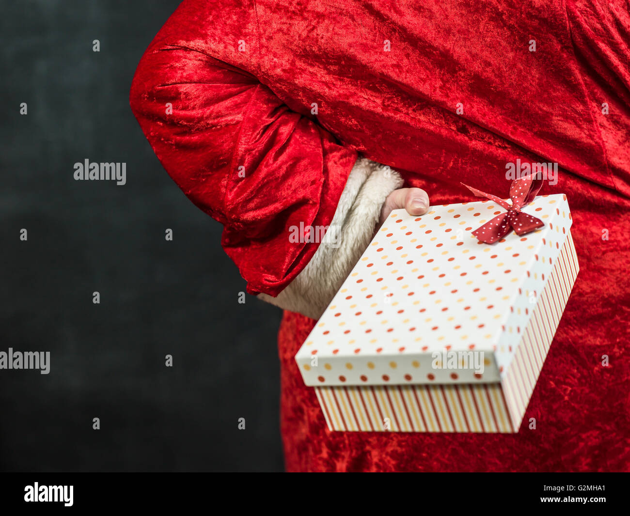 Santa sneaking in with a gift hidden behind his back Stock Photo - Alamy