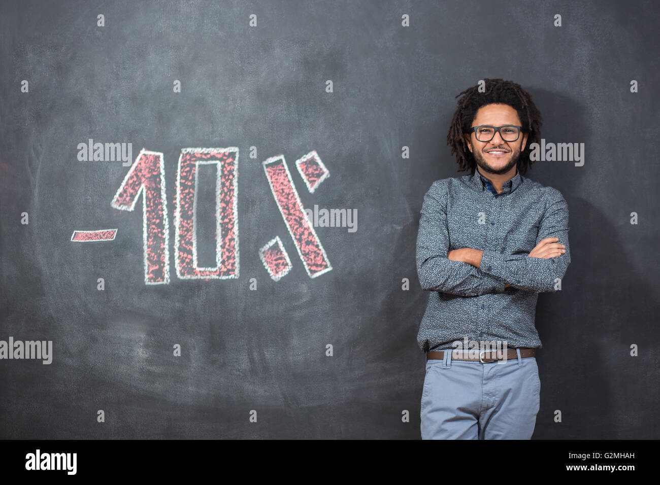 mixed race afro man standing in front of chalkboard with discount ...