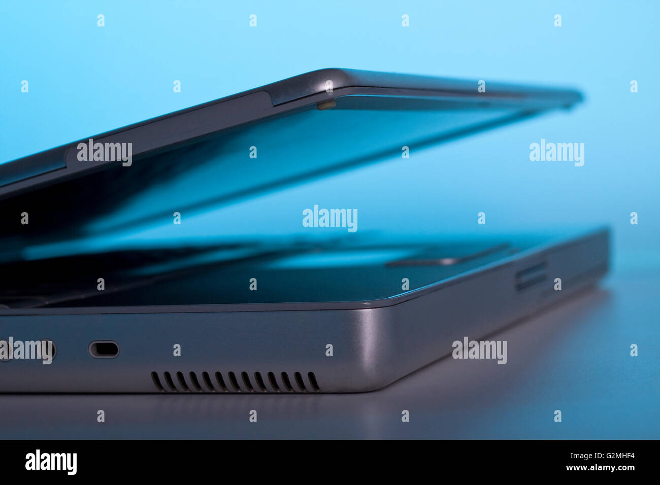 silver laptop on blue light background with the lid open Stock Photo ...
