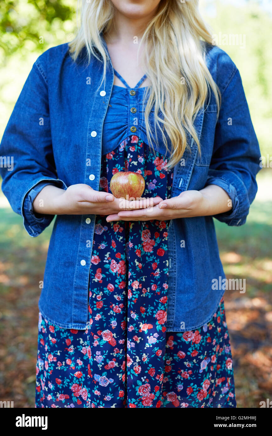 Apple woman. Very beautiful ethnic model eating red apple in the park ...