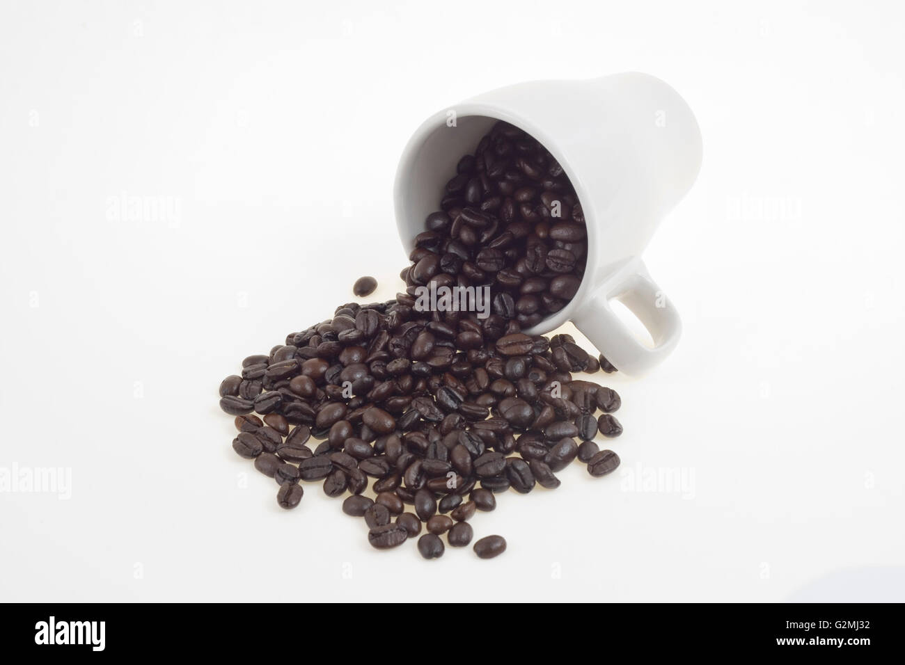 coffee beans falling from a white mug Stock Photo - Alamy