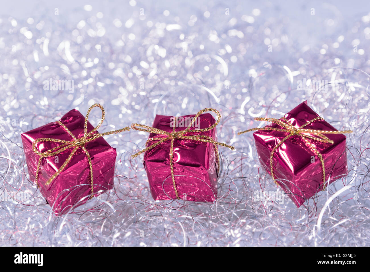 Three presents on a silver glitter ground Stock Photo - Alamy