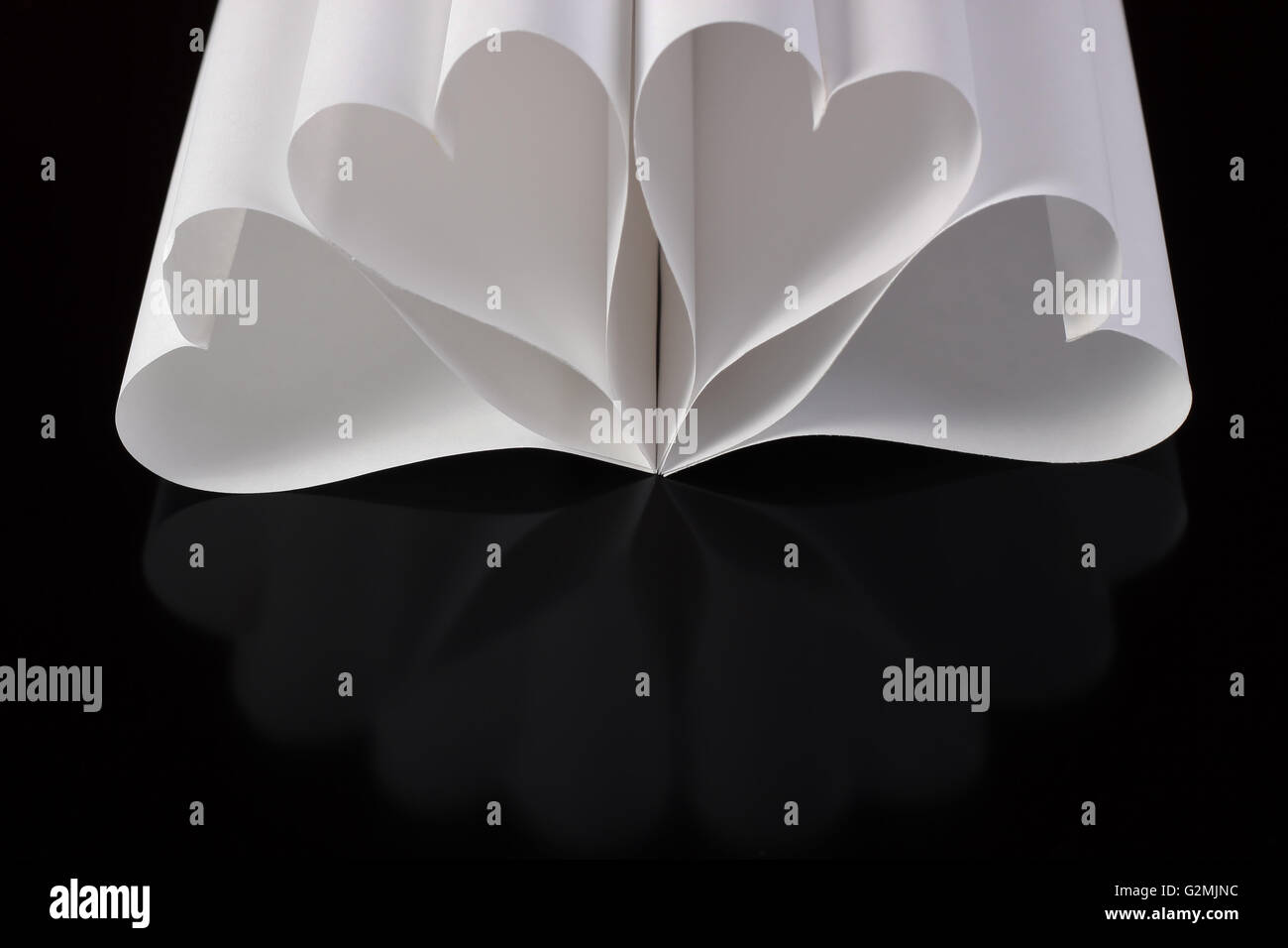 white paper hearts on black table with reflection Stock Photo - Alamy