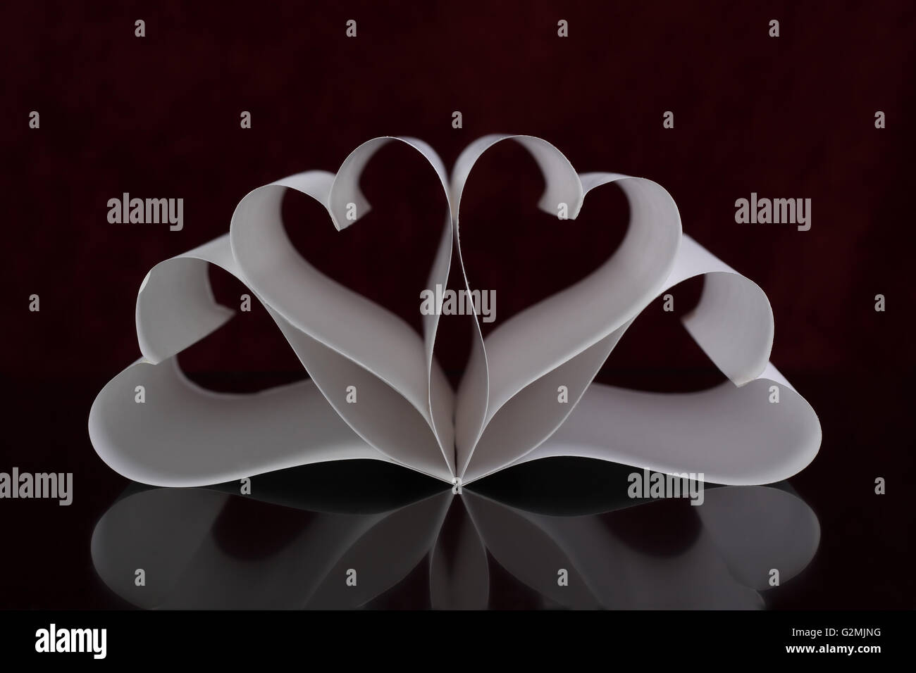 four paper hearts front view with red background and reflection on ...