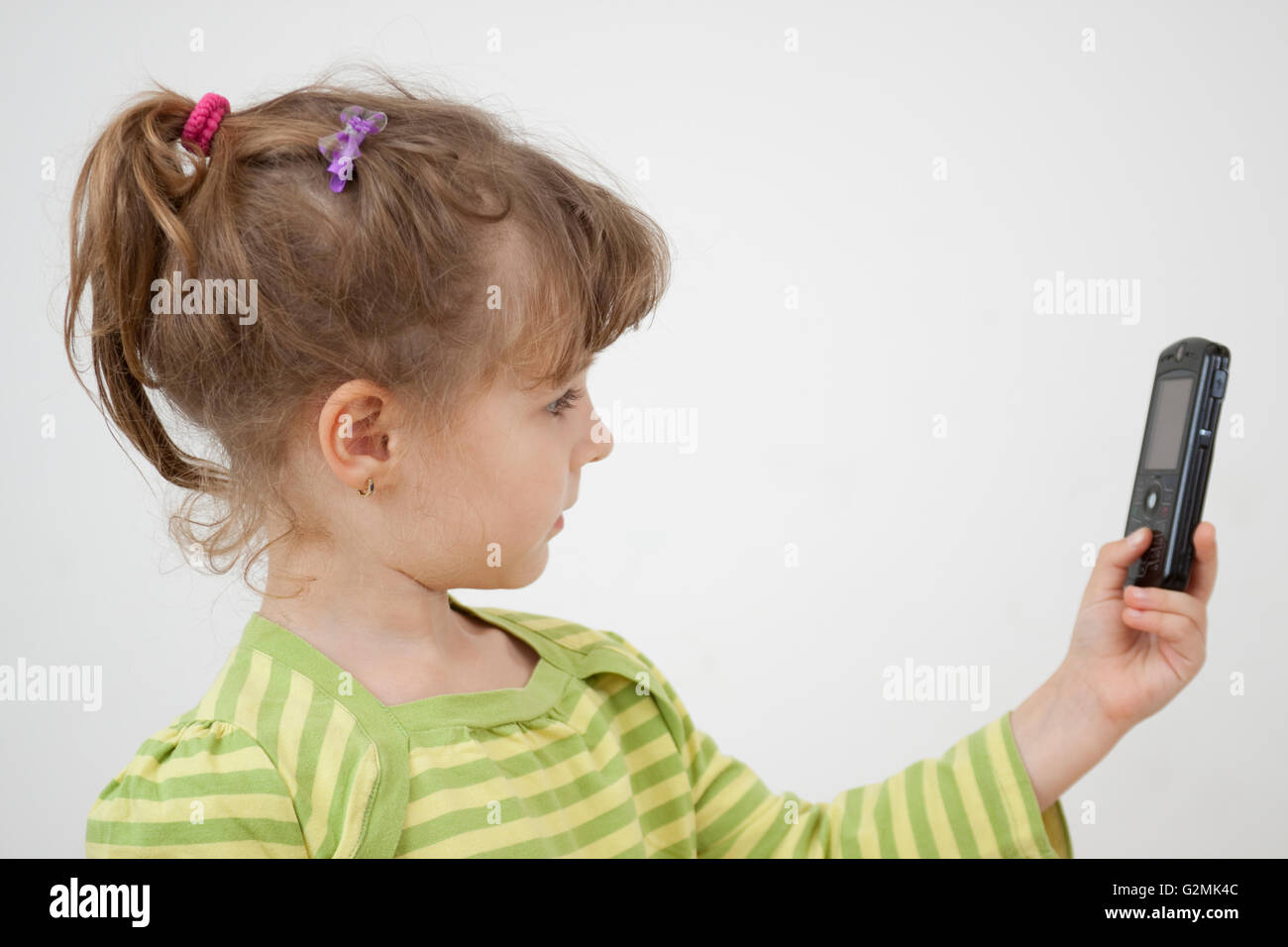 small girl playing with cellphone Stock Photo - Alamy