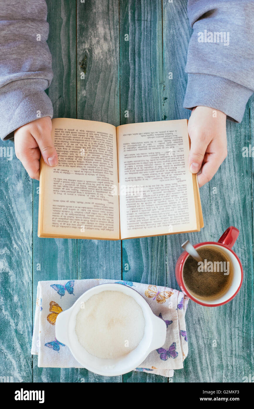 Man reading a book and writing notes on wooden table Stock Photo - Alamy