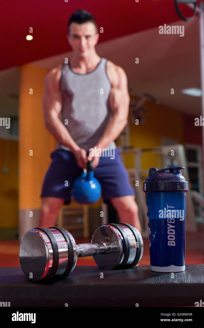 Whey protein shaker and dumbbells. Fitness and bodybuilding man in ...