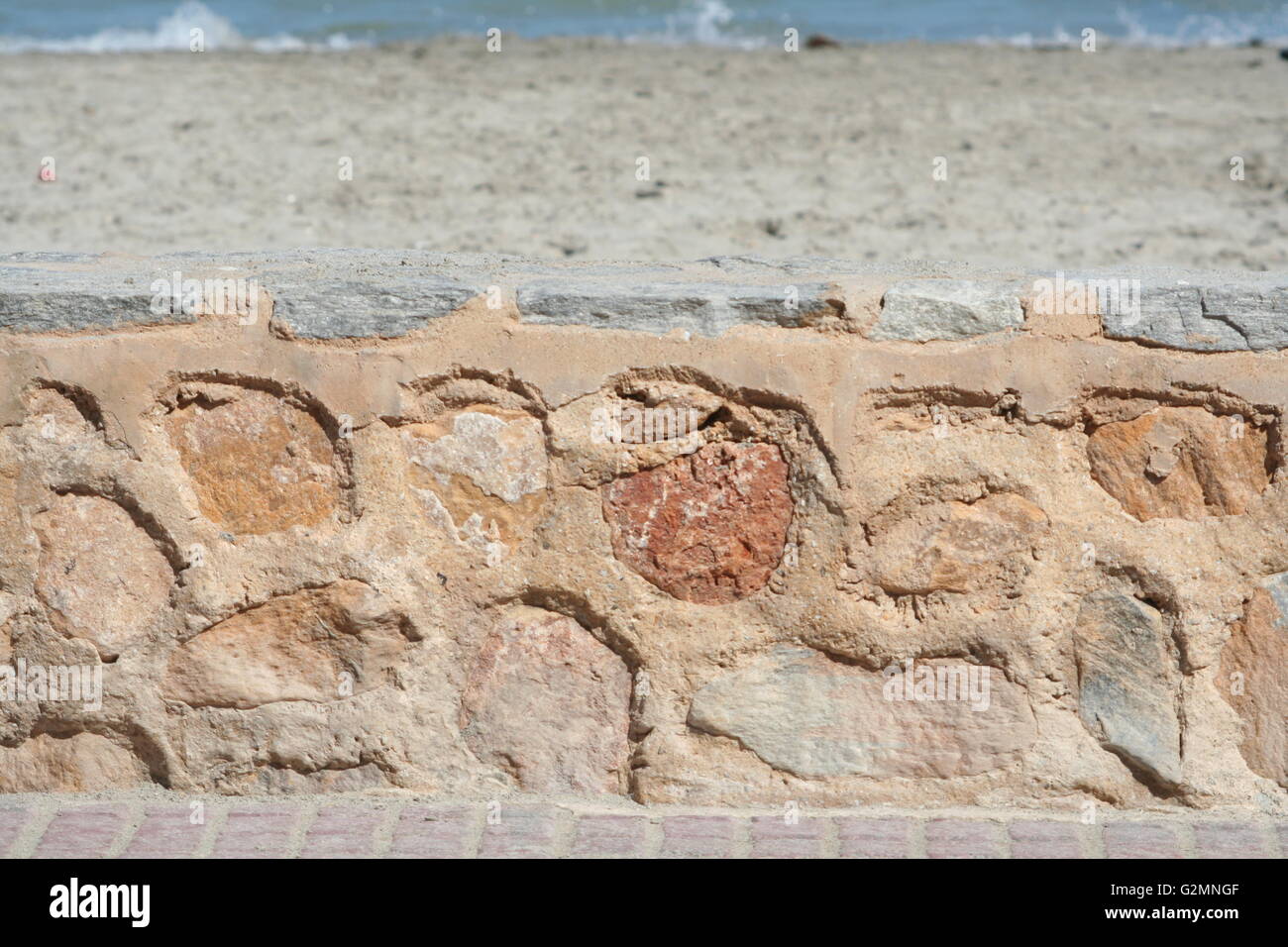 Wall separating the beach and the path Stock Photo - Alamy