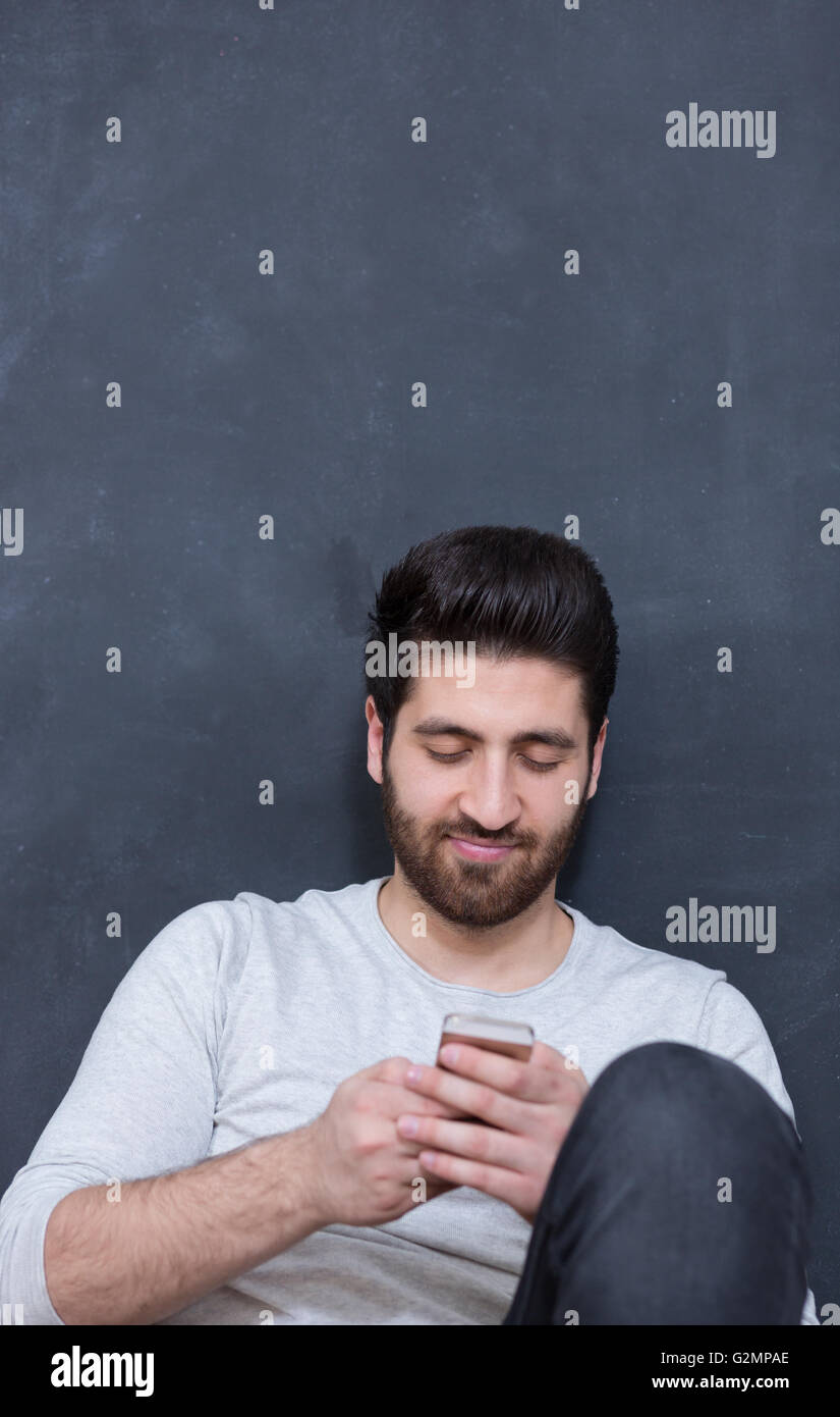 Casually handsome. Handsome young arabic man holding cell phone while ...