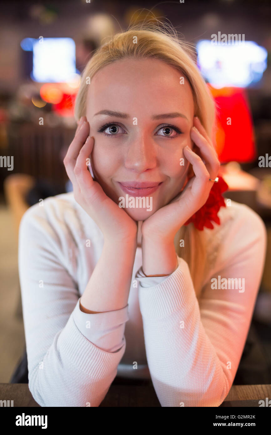 Woman with hand to face smiles at viewer Stock Photo - Alamy