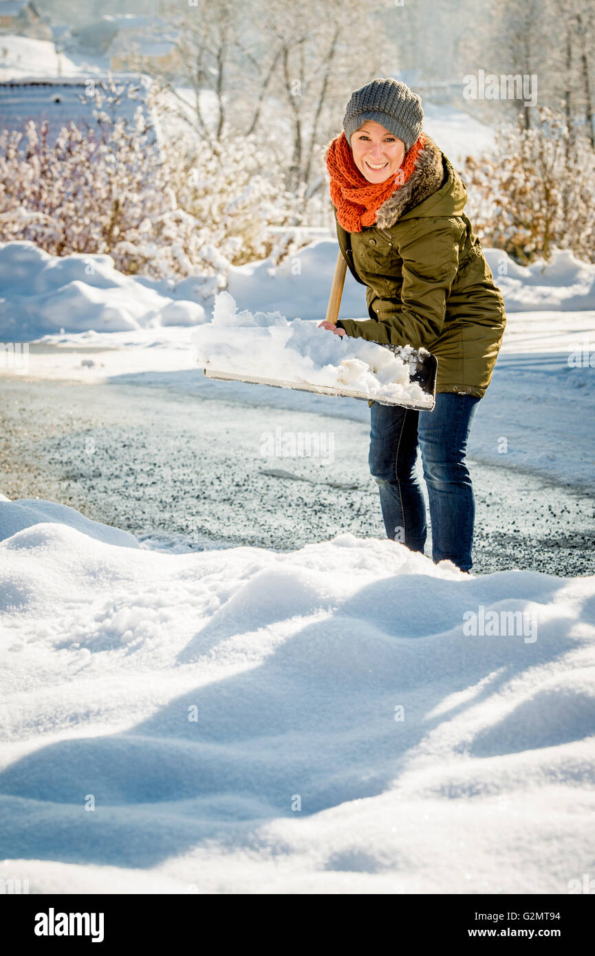 Woman shovelling snow Stock Photo - Alamy