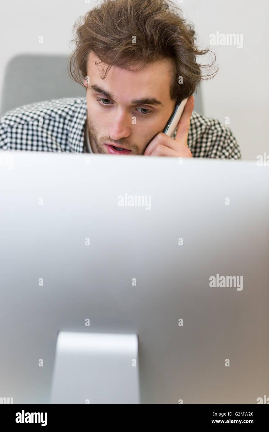 Man looking at a computer screen, thinking about the job at hand Stock ...