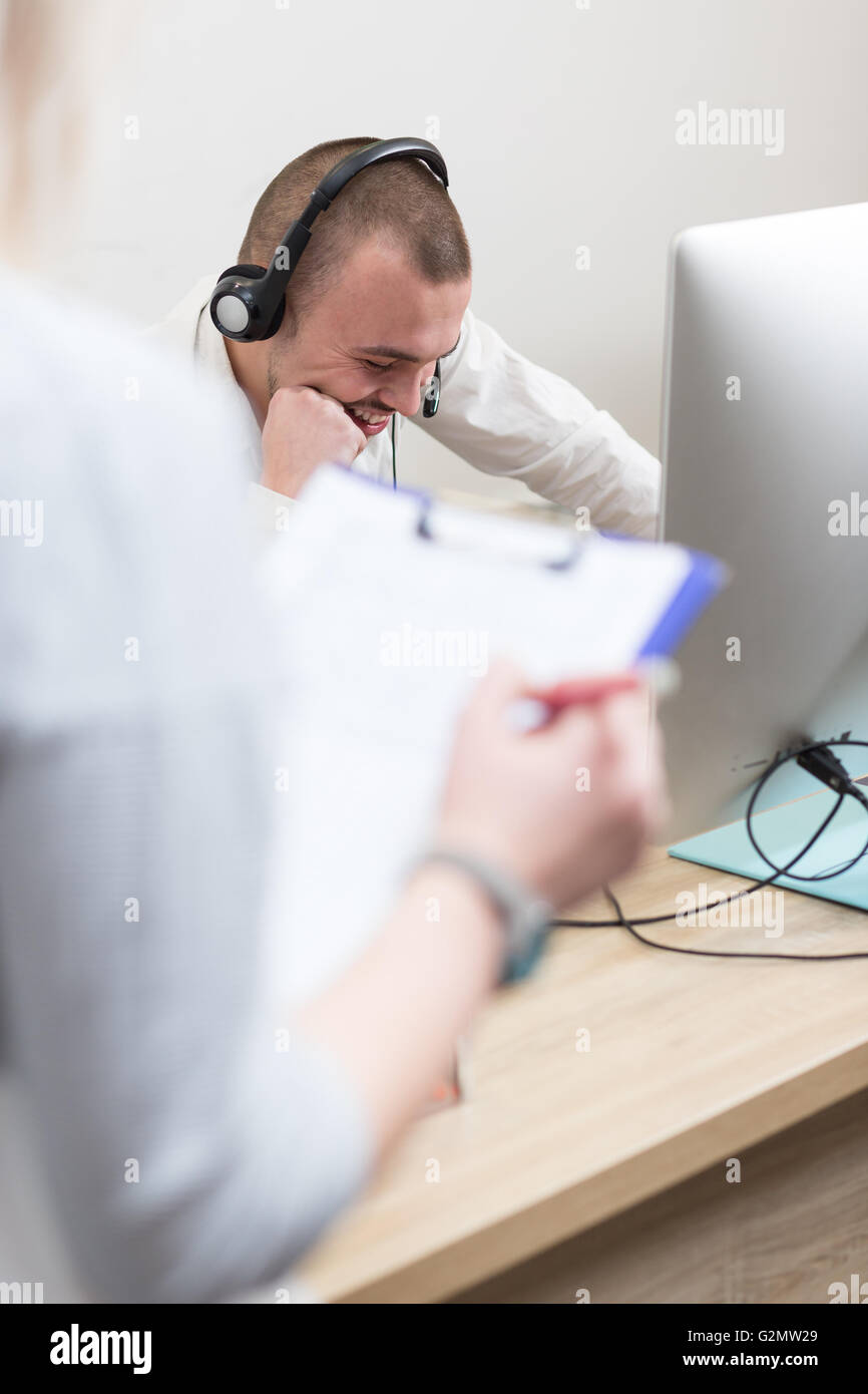 Portrait of female manager checking her staffs work in a call center ...