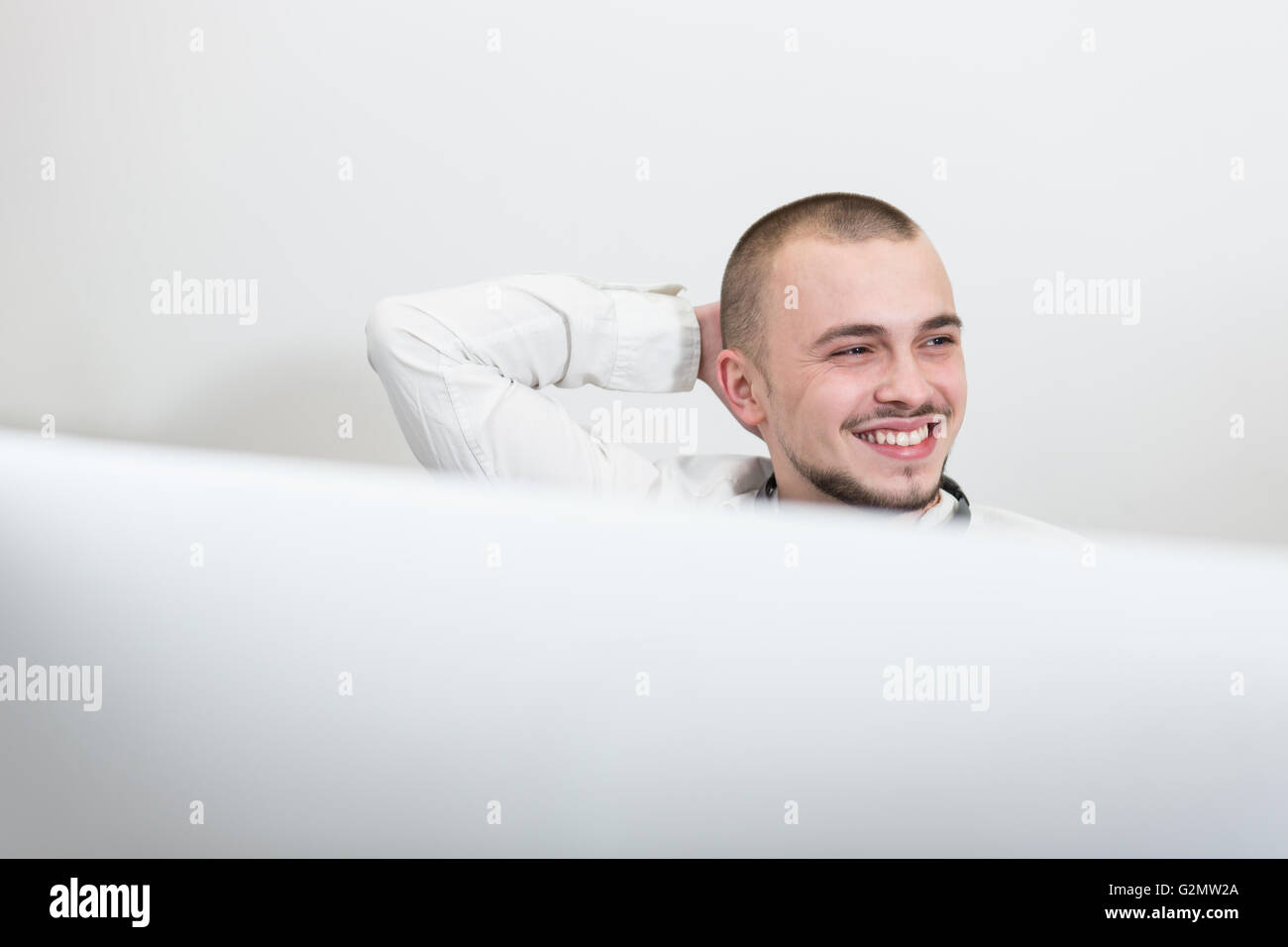 Contented businessman taking a break sitting back in his chair at the ...