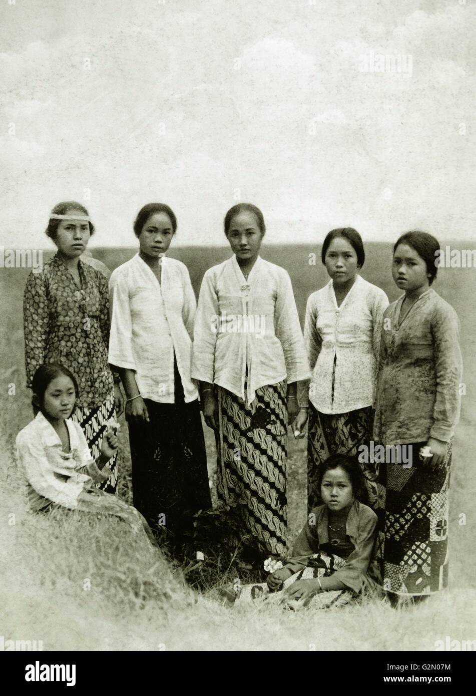 Photograph shows a group of Sundanese women standing in an open field ...