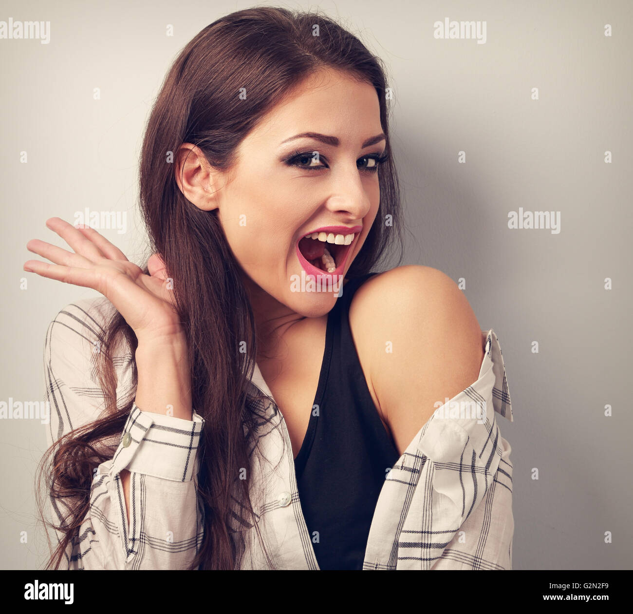 Happy excited young woman screaming with open mouth. Toned closeup ...