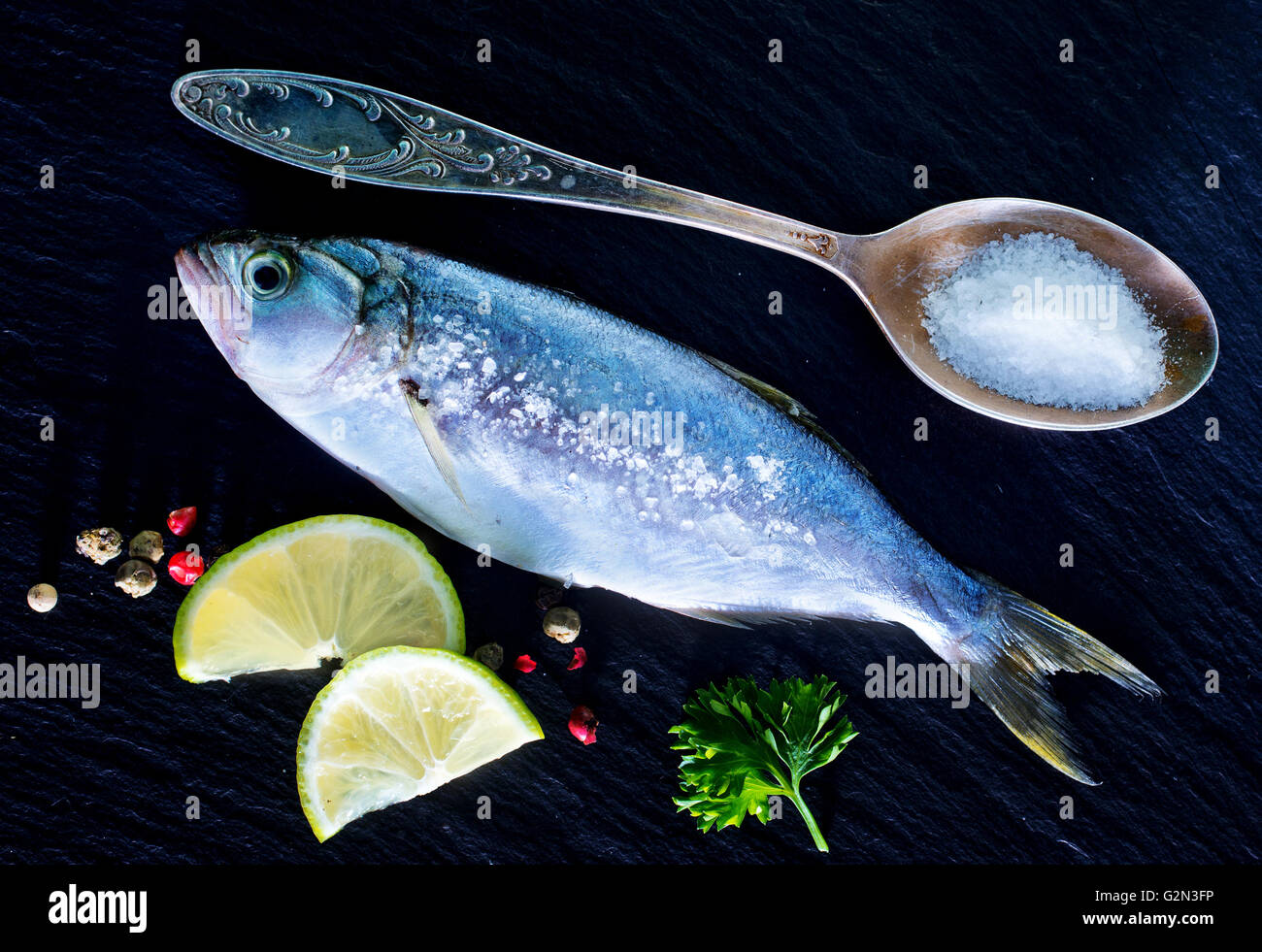 raw fish and salt on the black board Stock Photo - Alamy