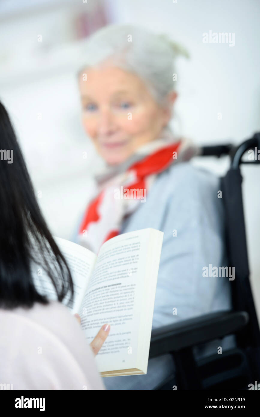 Helping senior woman to read Stock Photo - Alamy