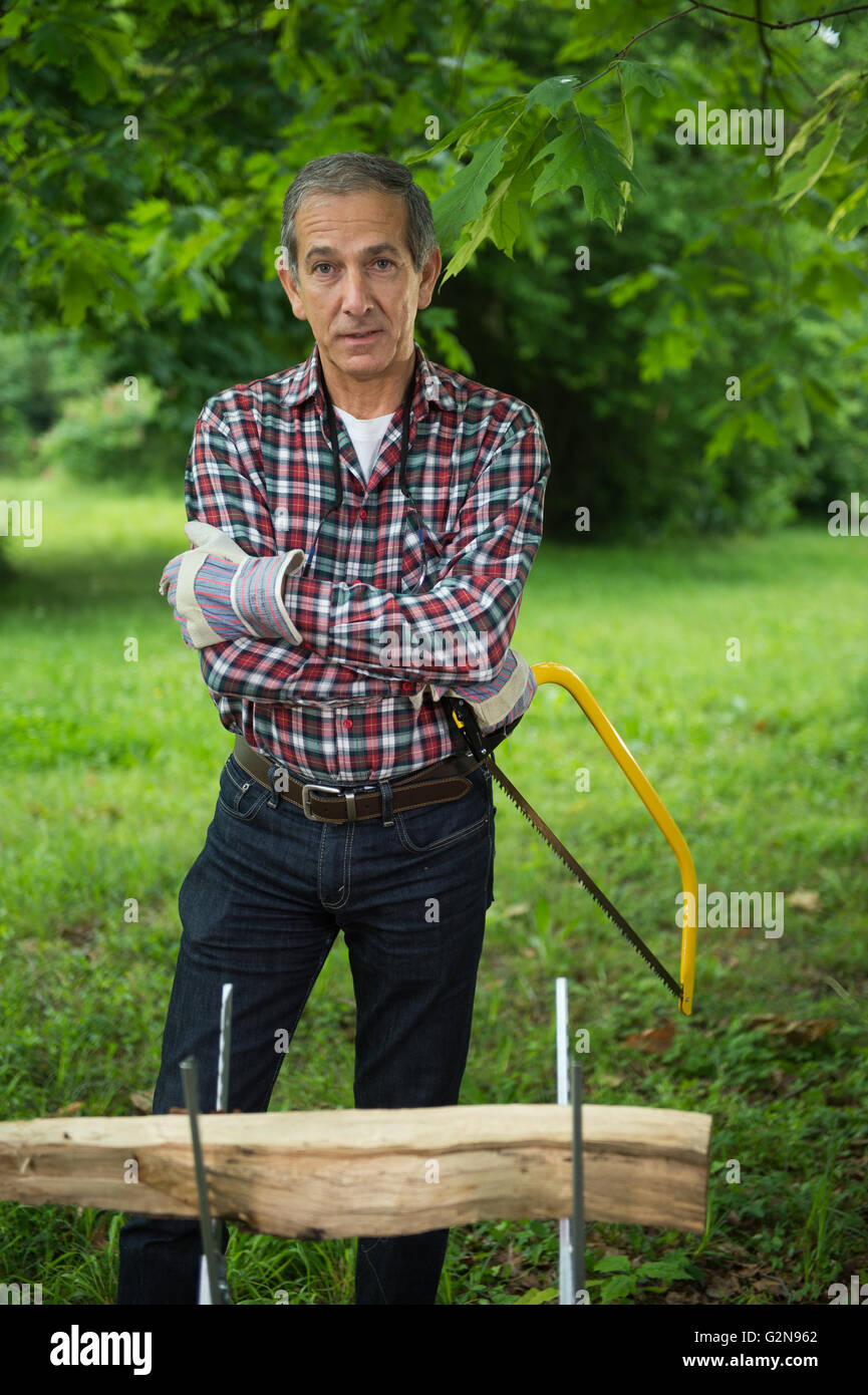 Senior man sawing a log handsaw closeup Stock Photo - Alamy