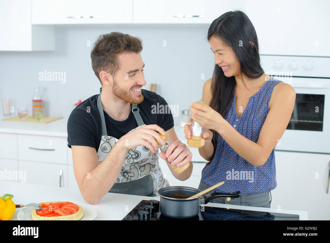 Happy couple cooking together Stock Photo - Alamy
