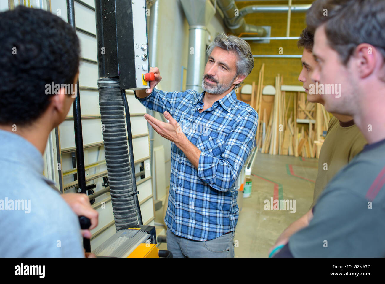 Teacher showing students machine with extractor hose Stock Photo - Alamy
