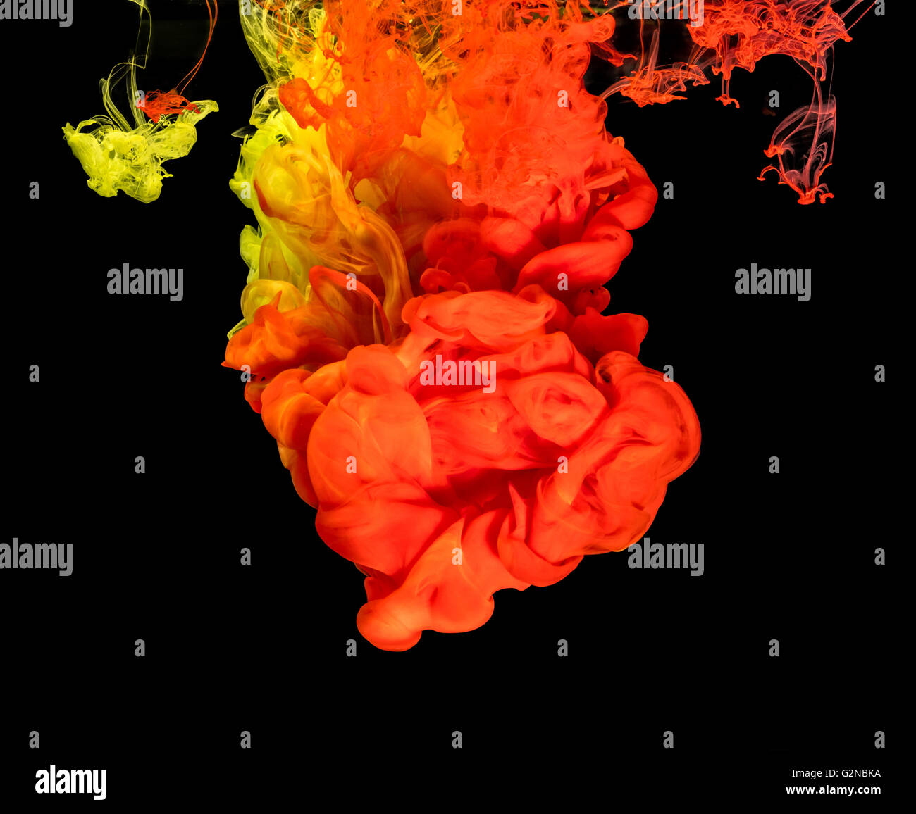 Mix of colored ink in water creating abstract shape, isolated on black ...