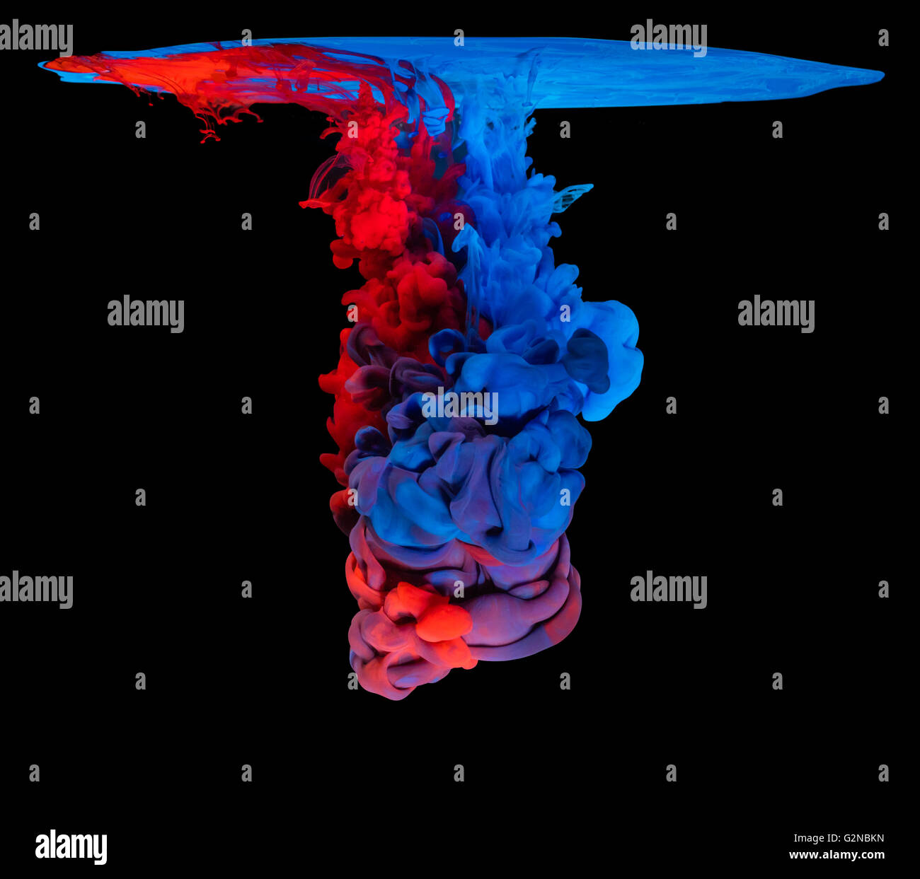 Mix of colored ink in water creating abstract shape, isolated on black ...