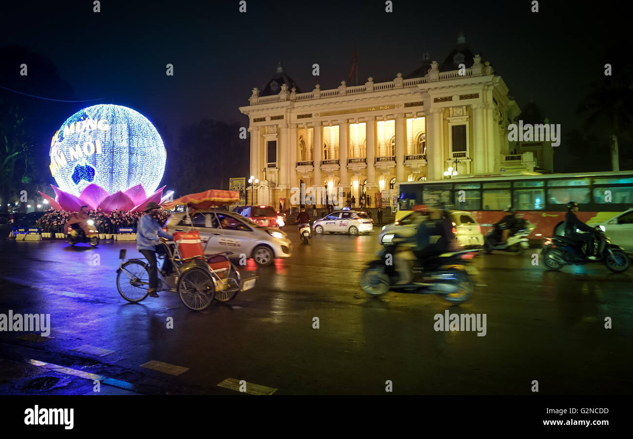 The opera house at night with traffic including cars, Hanoi, Vietnam ...