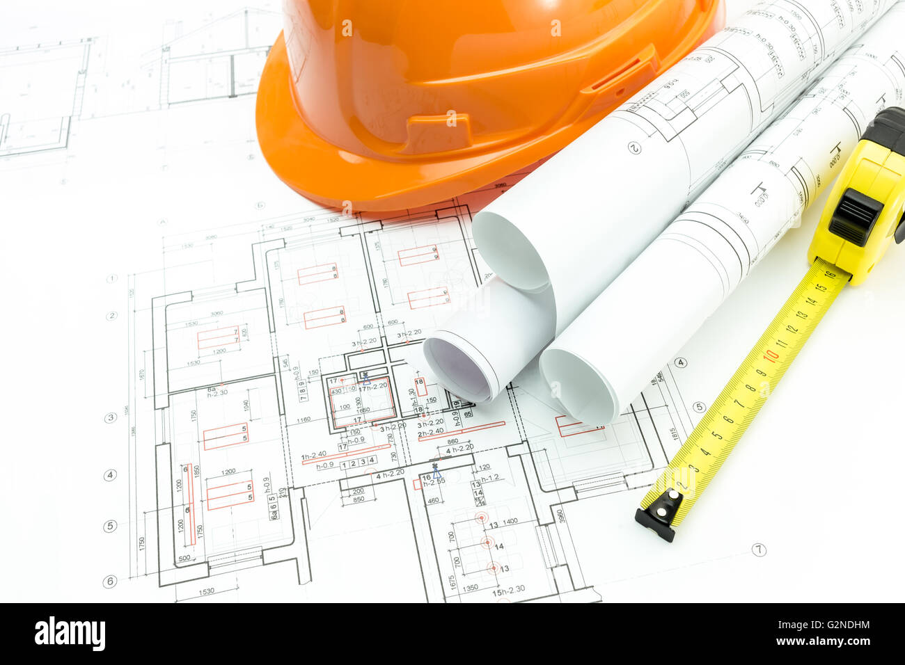 Safety orange helmet with tape measure and rolls of architectural ...