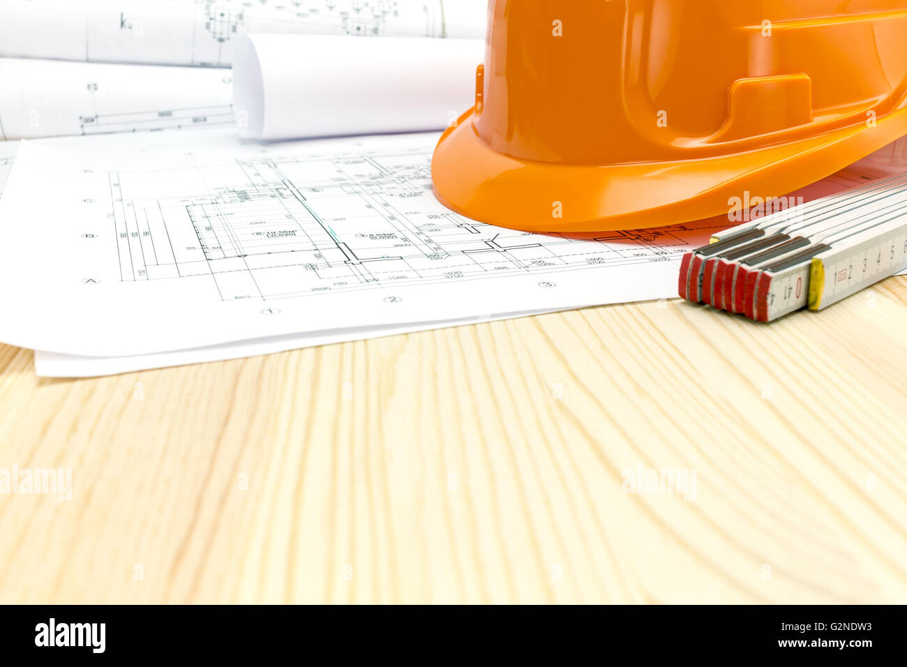 protective helmet and folding rule on top of architectural drawings ...