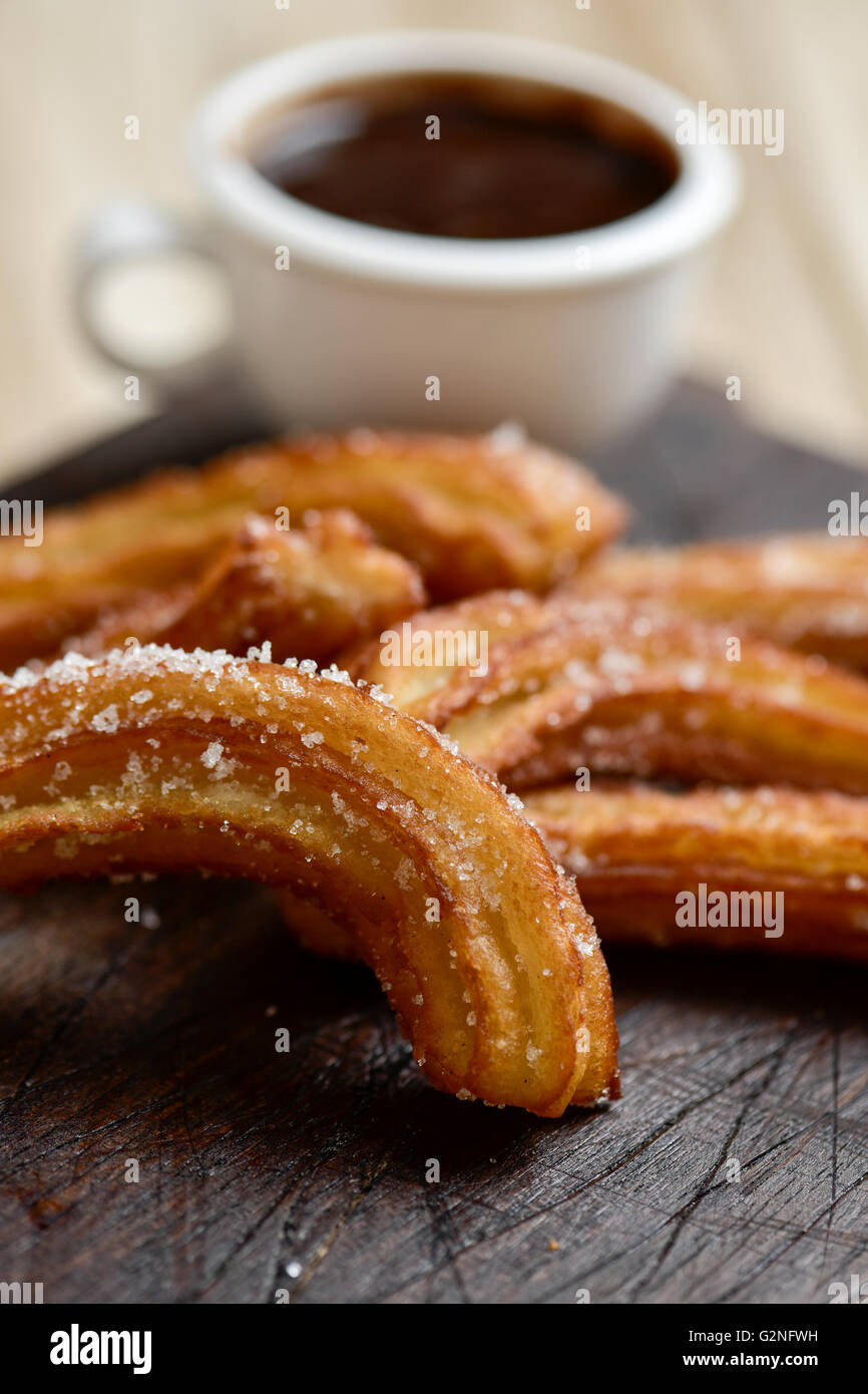 churros con chocolate, a typical Spanish sweet snack, on a rustic ...