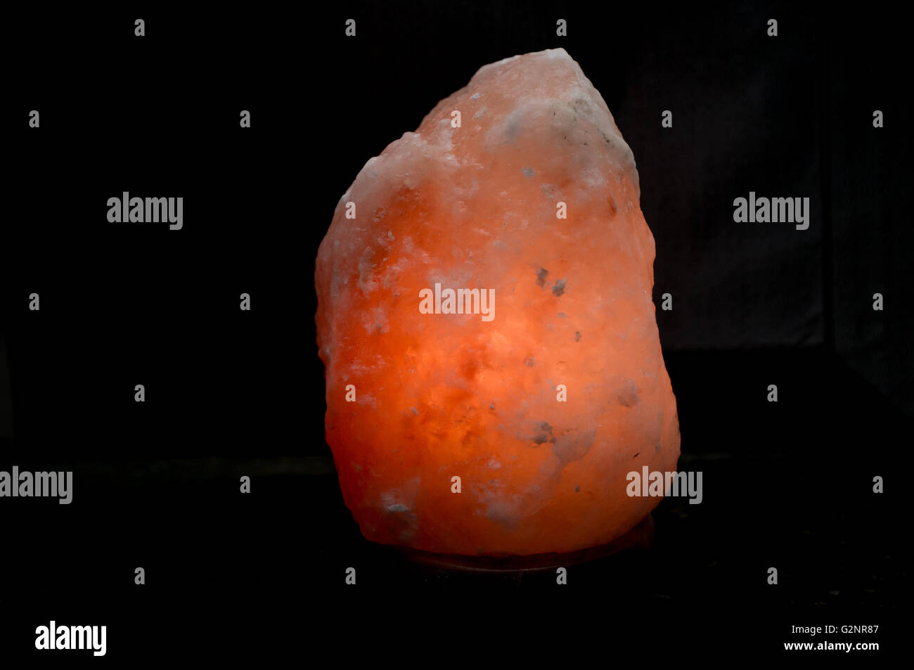 Glowing pink himalayan sea salt lamp on dark background Stock Photo - Alamy