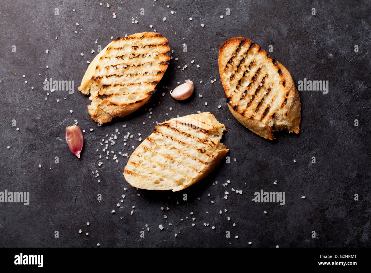 Toast bread with salt and garlic on stone table. Top view Stock Photo ...