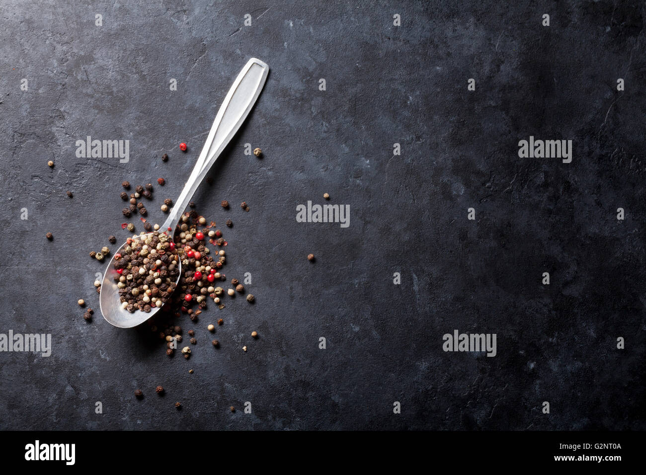Mixed peppercorn. Red, white and black pepper spices in spoon on stone ...