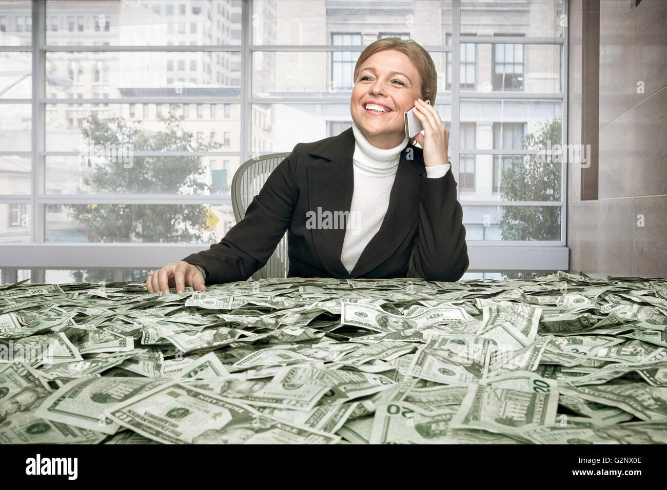 portrait of young woman sitting behind the table full of cash Stock ...