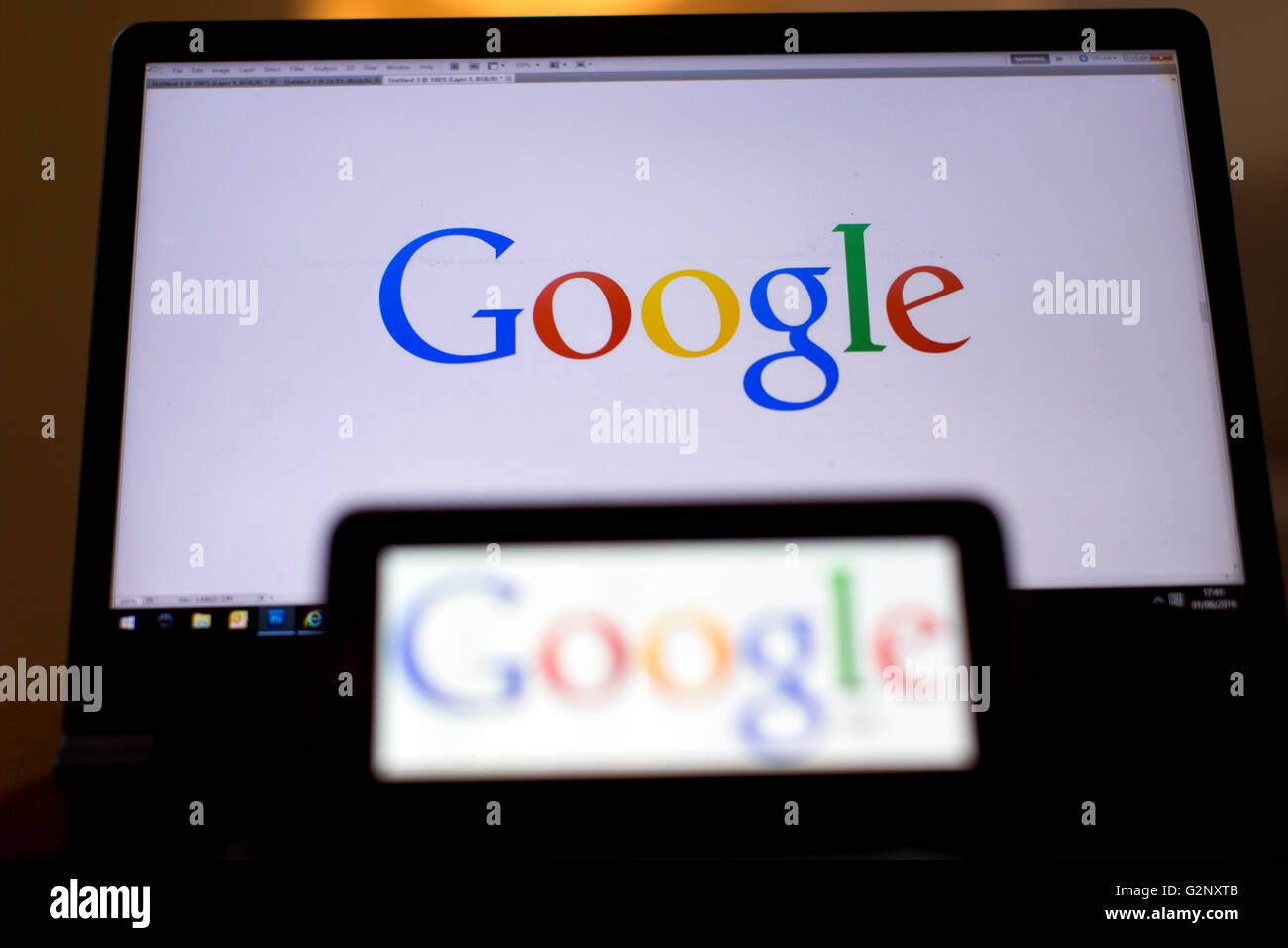 Google UK search engine logos are pictured on phone and laptop screens ...