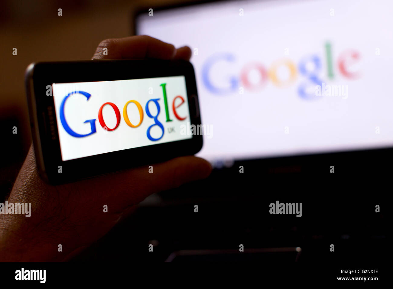 Google UK search engine logos are pictured on phone and laptop screens ...
