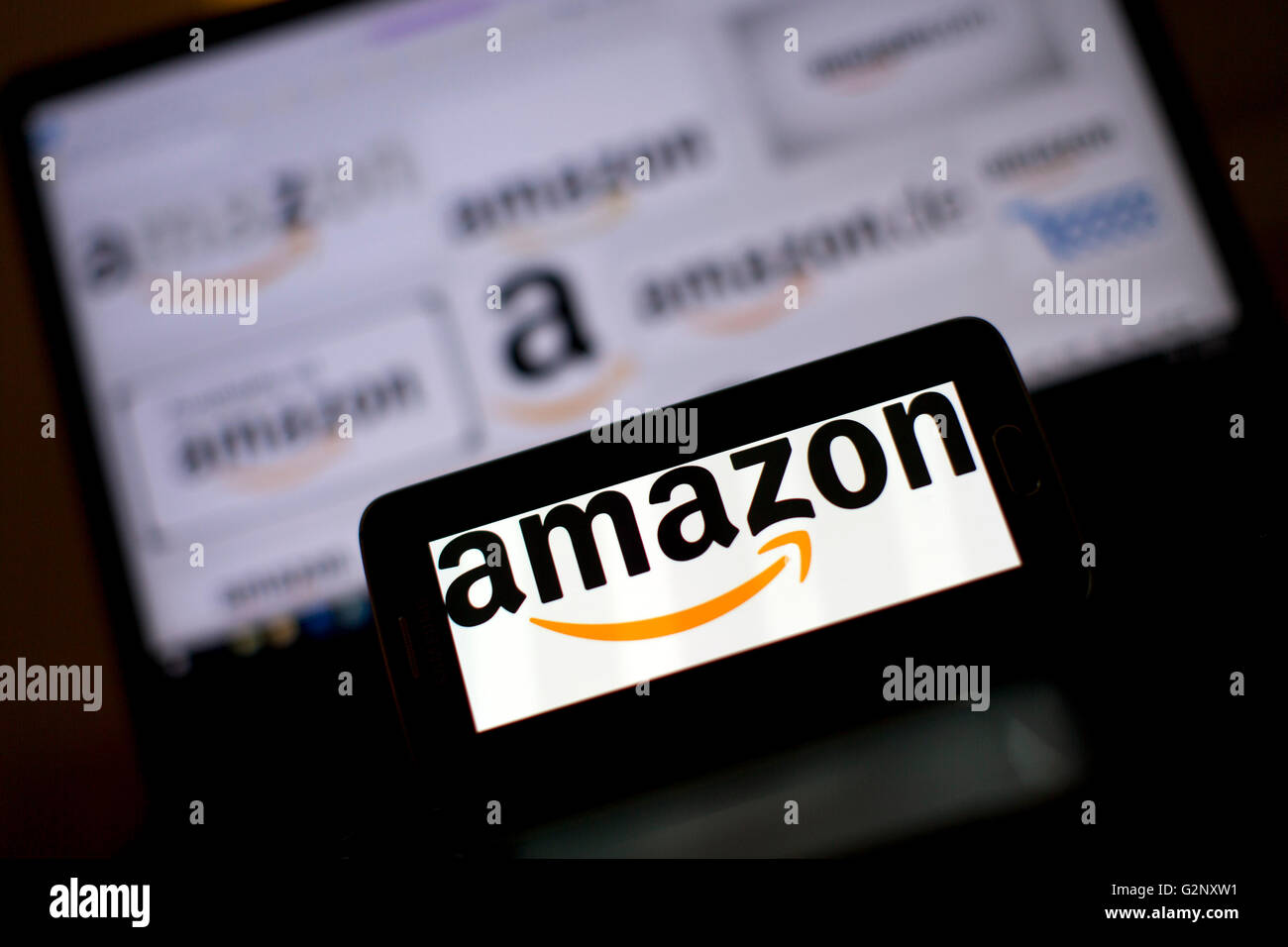 Amazon online retailer logos are pictured on phone and laptop screens ...