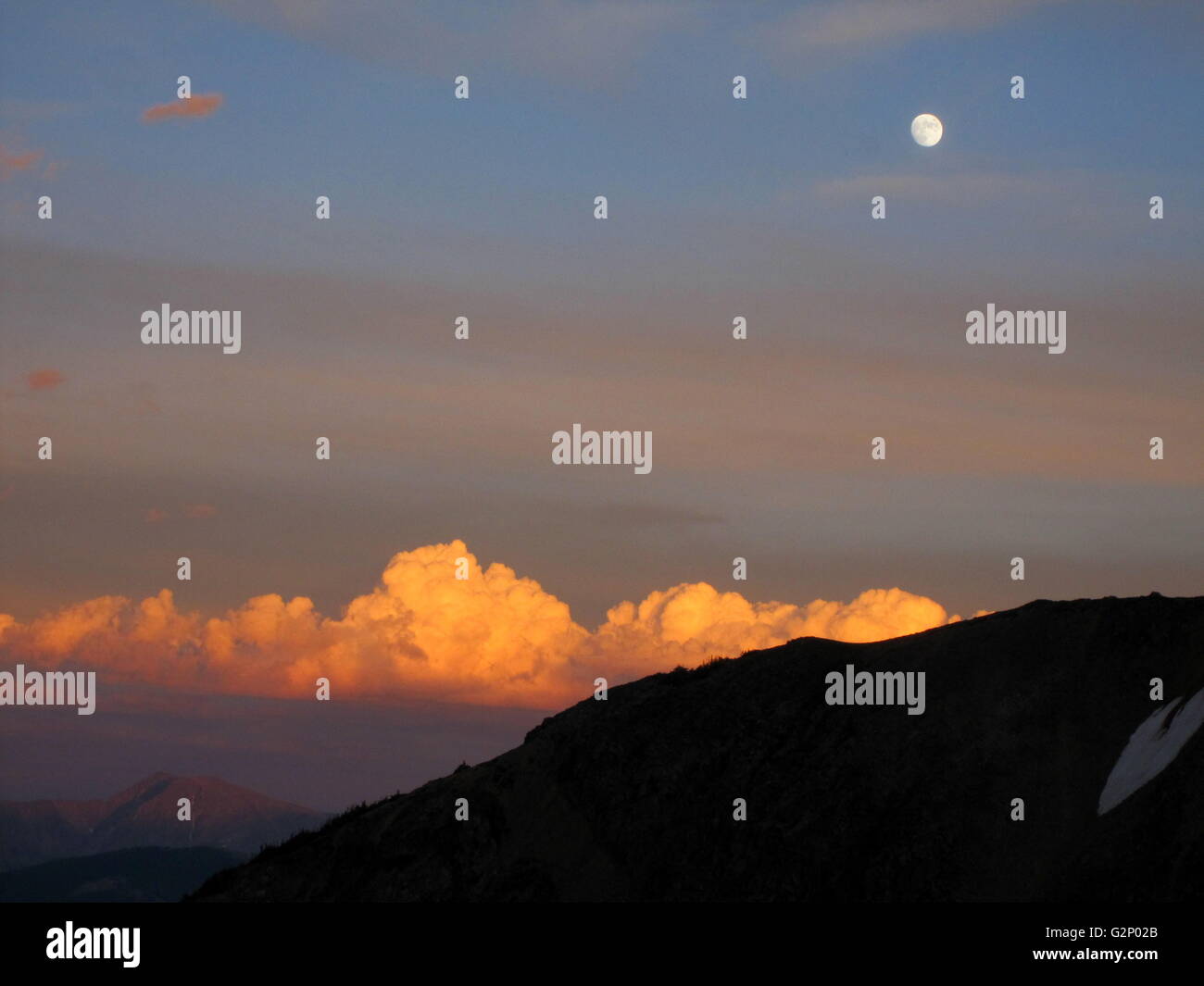 Evening sky with sun-lit clouds and moon Stock Photo - Alamy