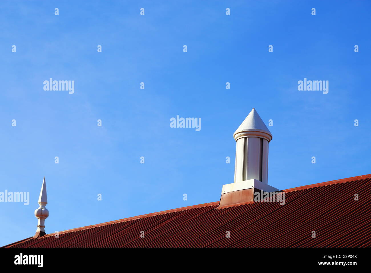 Two different roof spire type ornaments atop a red roof and a bright ...