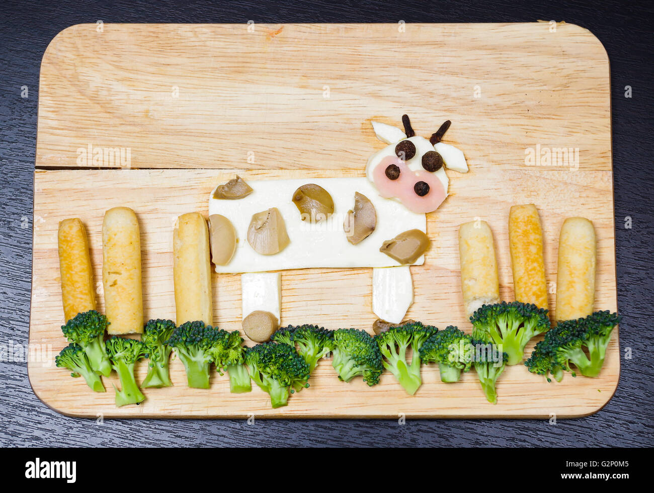Cow with landscape made from cheese, white carrots, broccoli, mushroom ...