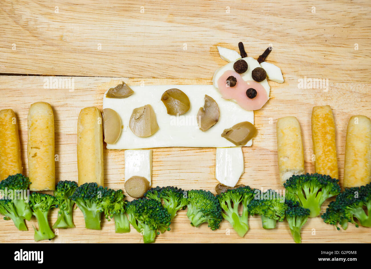 Cow with landscape made from cheese, white carrots, broccoli, mushroom ...