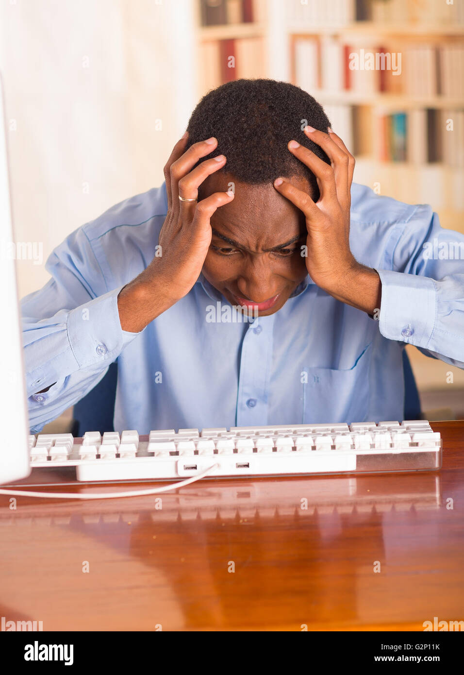 Young handsome man wearing blue office shirt sitting by computer ...