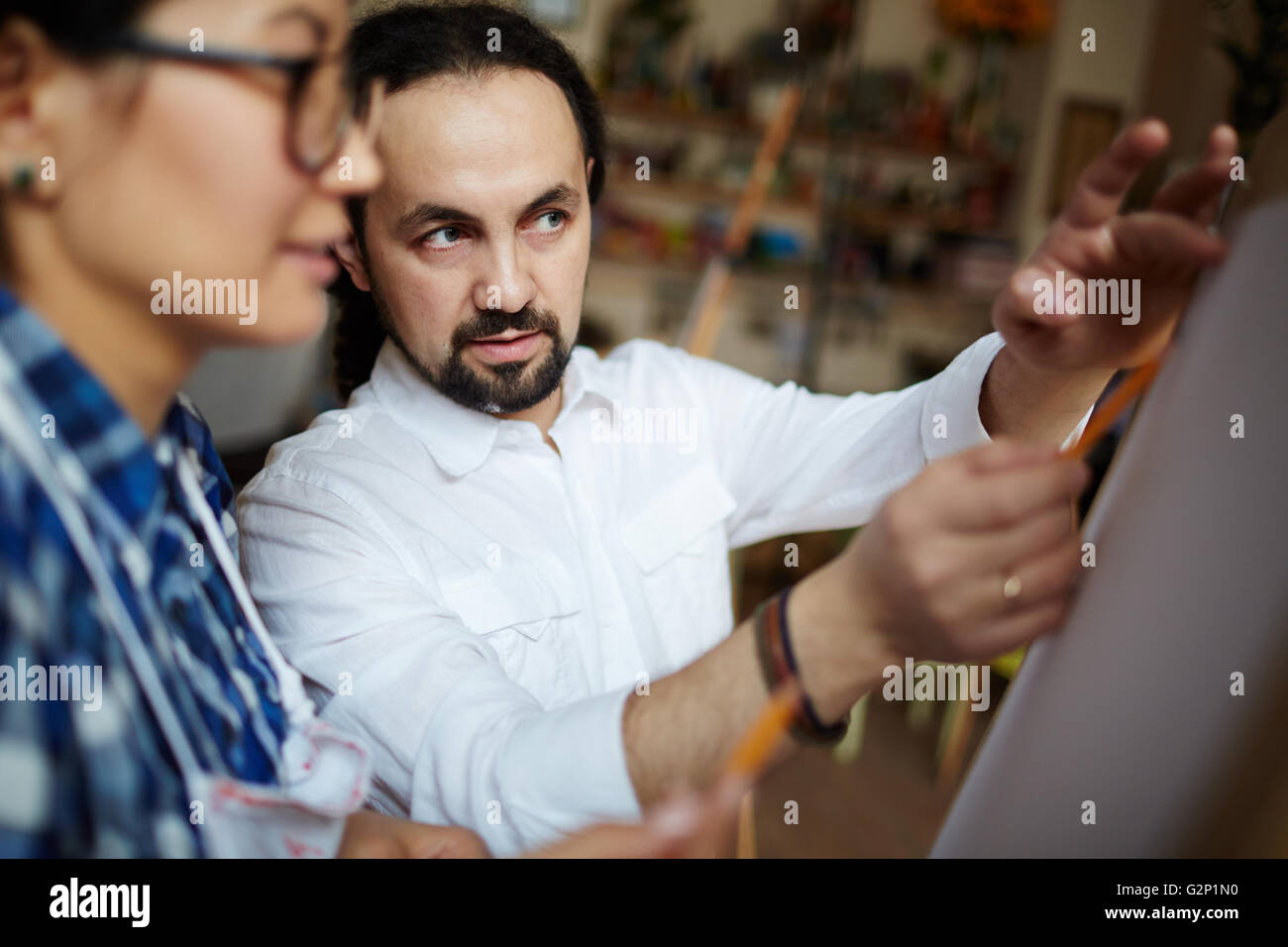 Tutor explaining student principles of drawing Stock Photo - Alamy