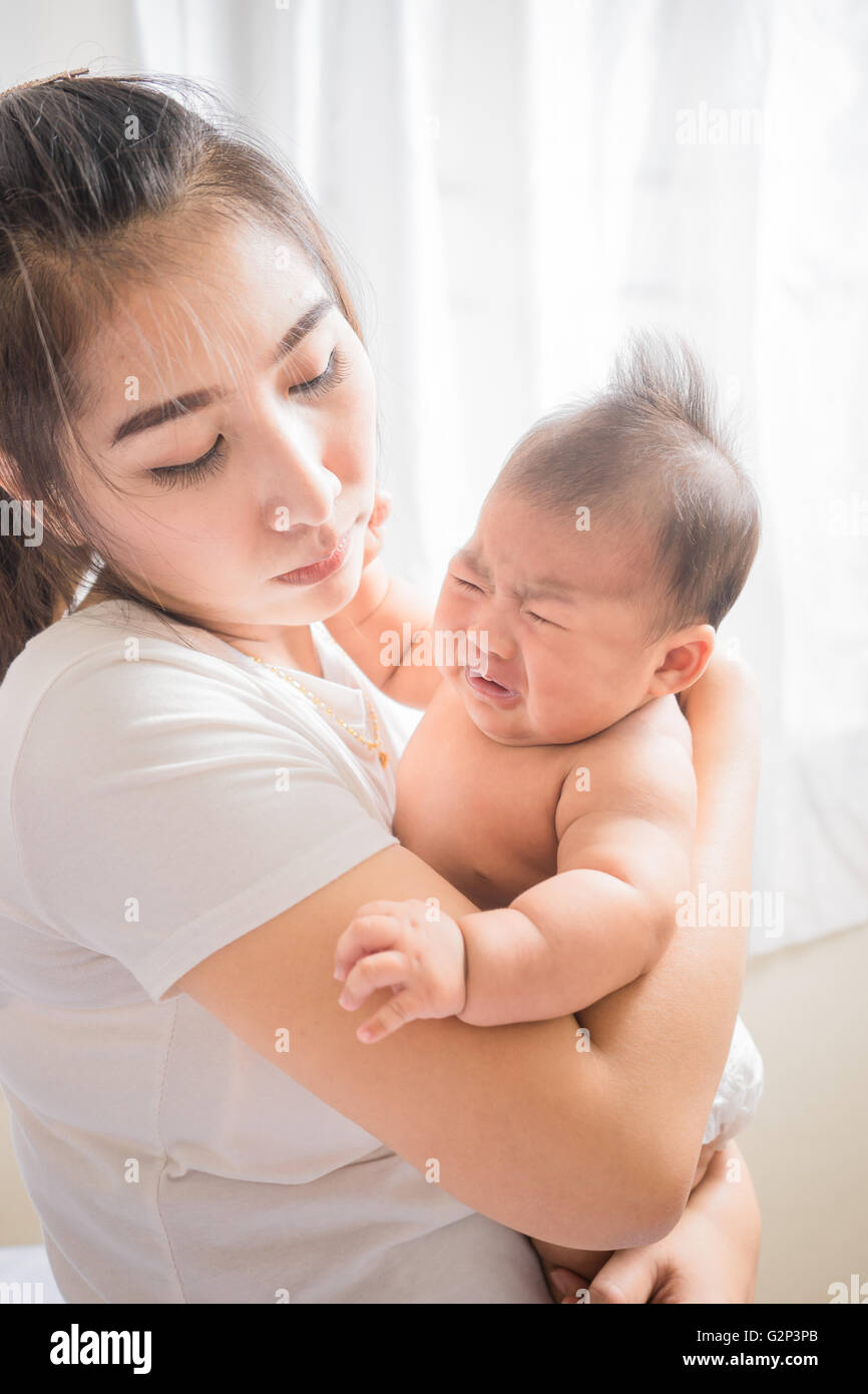 mother holding adorable child baby boy baby crying Stock Photo - Alamy